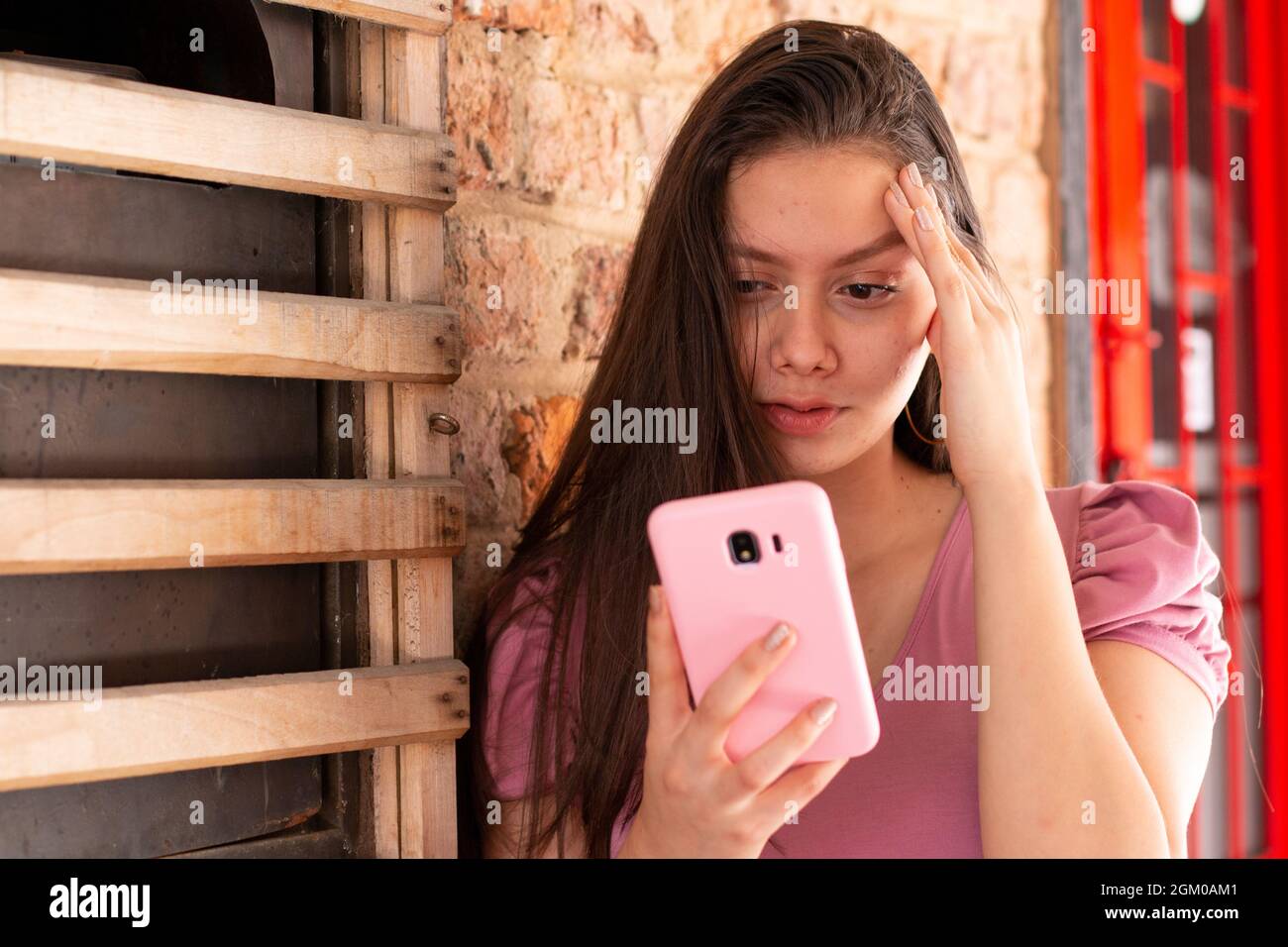 Woman with worried expression while looking at her cell phone Stock ...