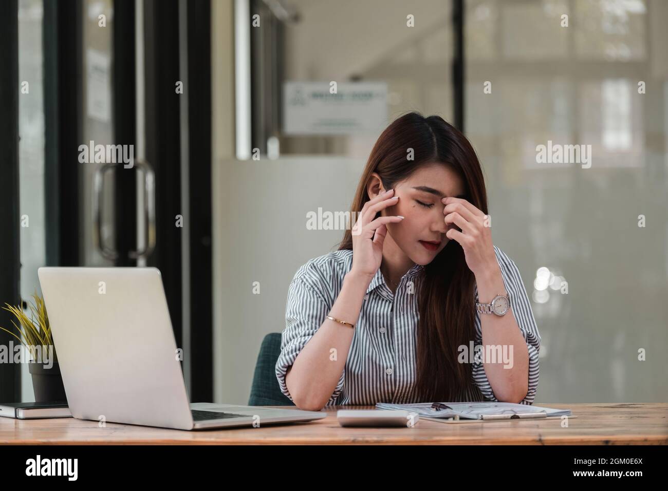 Stressed young woman sitting at desk working from home office ...