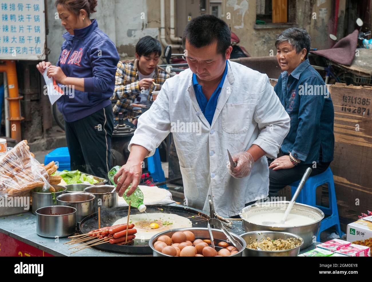 Cook working at a street food stall in Shanghai, China Stock Photo - Alamy