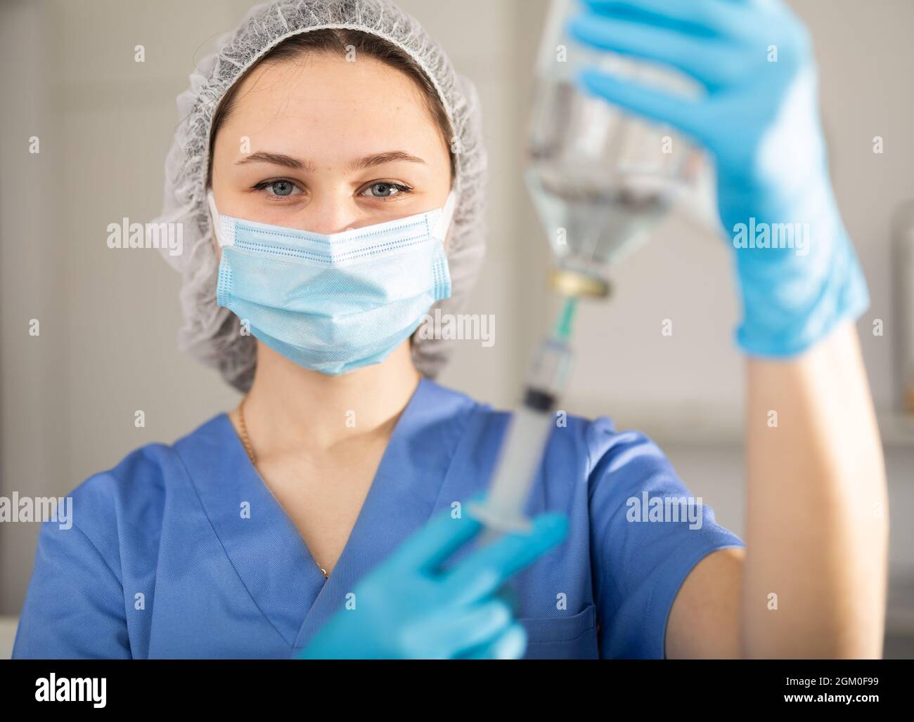 Young female nurse in the treatment room at the clinic prepares a ...
