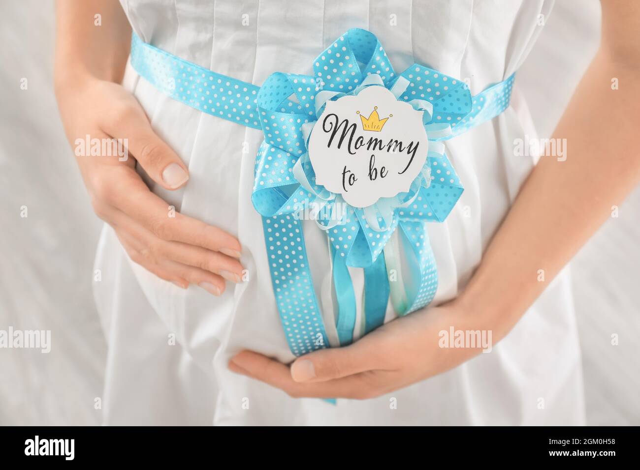 Pregnant woman with award ribbon on belly, closeup Stock Photo - Alamy