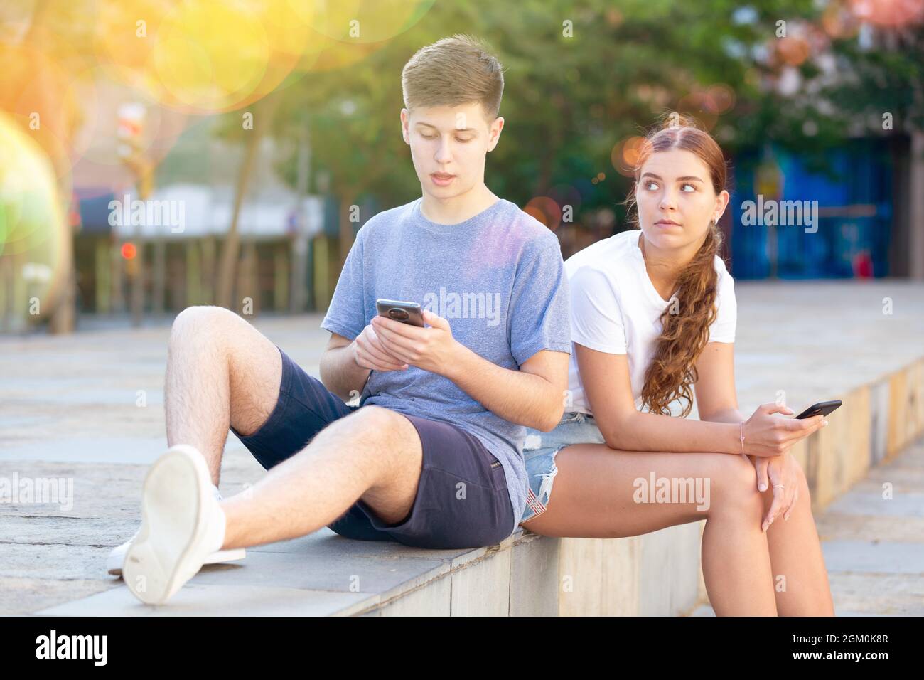 Two young people with mobile phones Stock Photo - Alamy