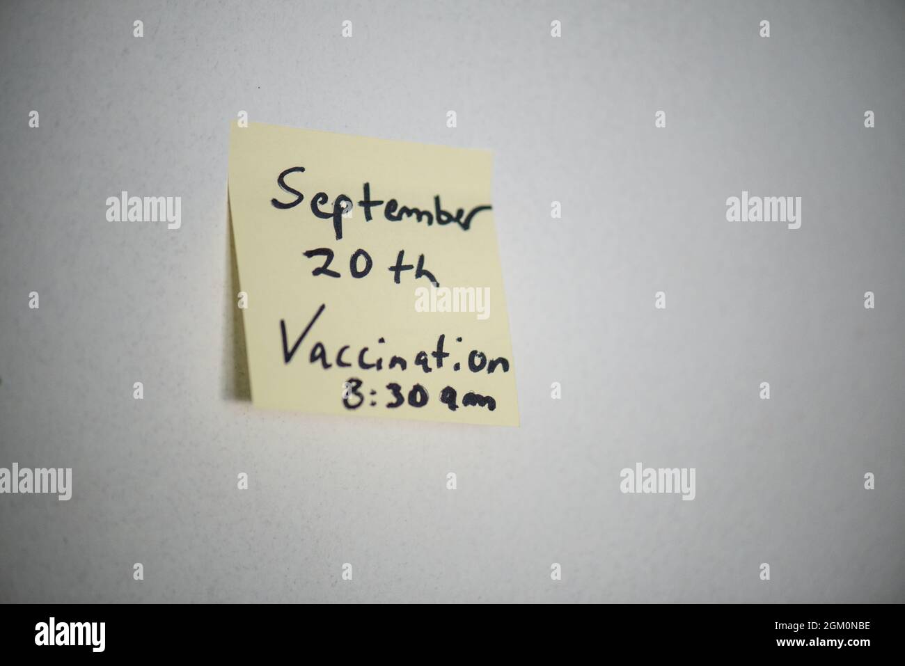 Handwritten sticky note on bulletin board to remember appointment date ...