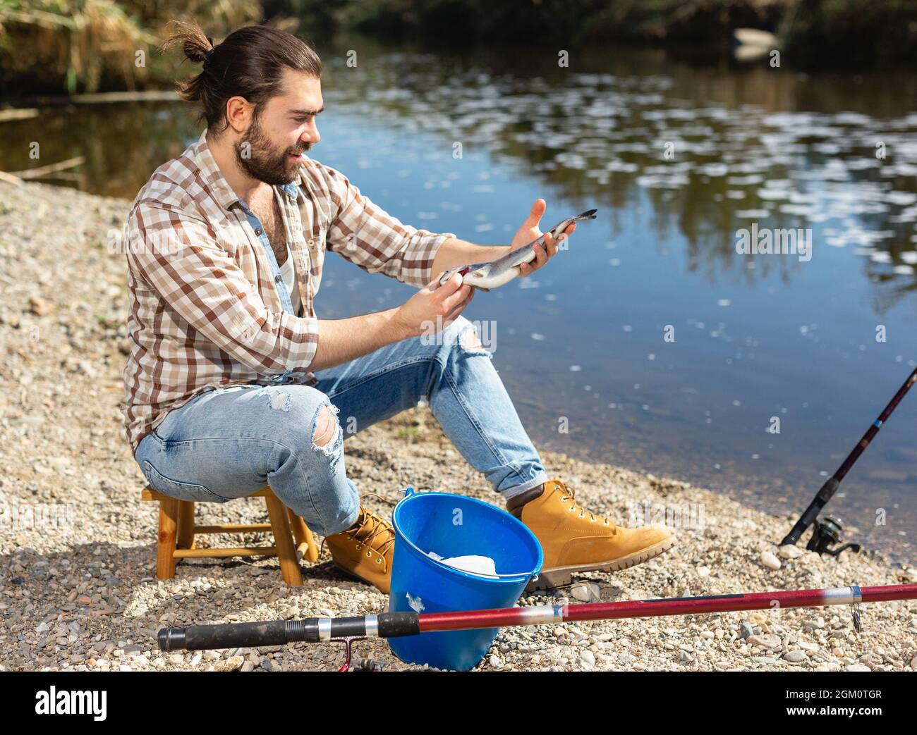 Adult male fisherman holding fish in his hands Stock Photo - Alamy