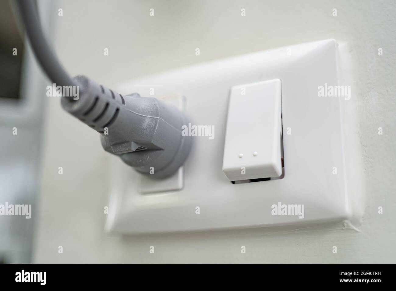Plug electric in the socket on wall at house Stock Photo - Alamy