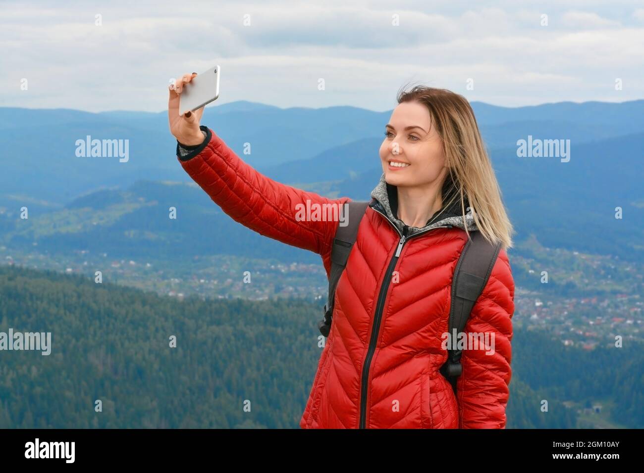 Beautiful young woman taking selfie against mountain landscape Stock ...