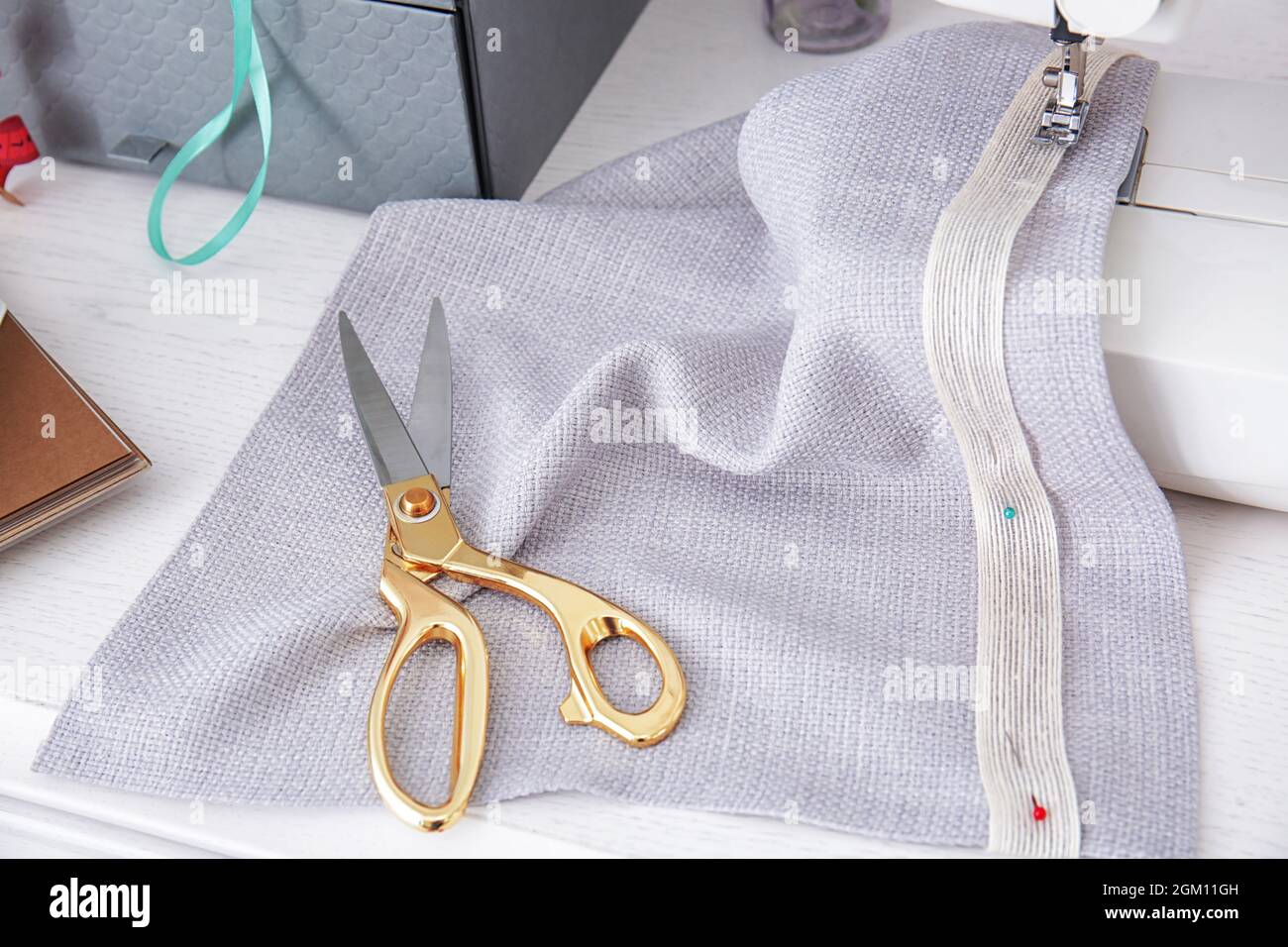 Fabric and tailor's scissors with sewing machine on table Stock Photo ...