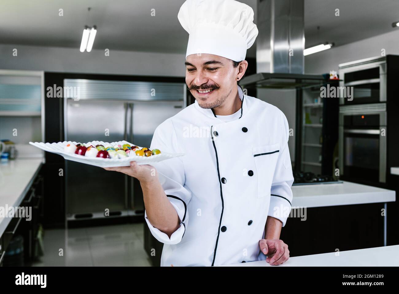young latin man chocolatier in chef hat standing with mexican ...