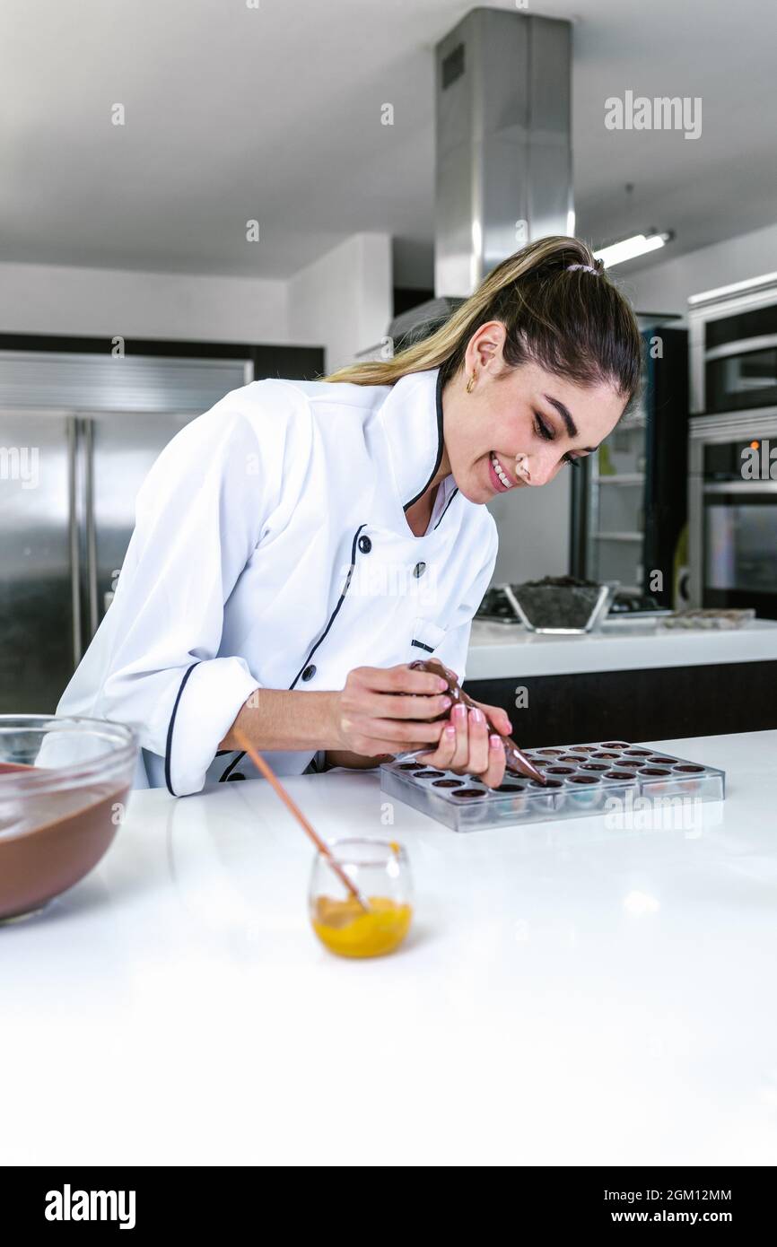 young latin woman chocolatier in chef hat with mexican chocolates ...