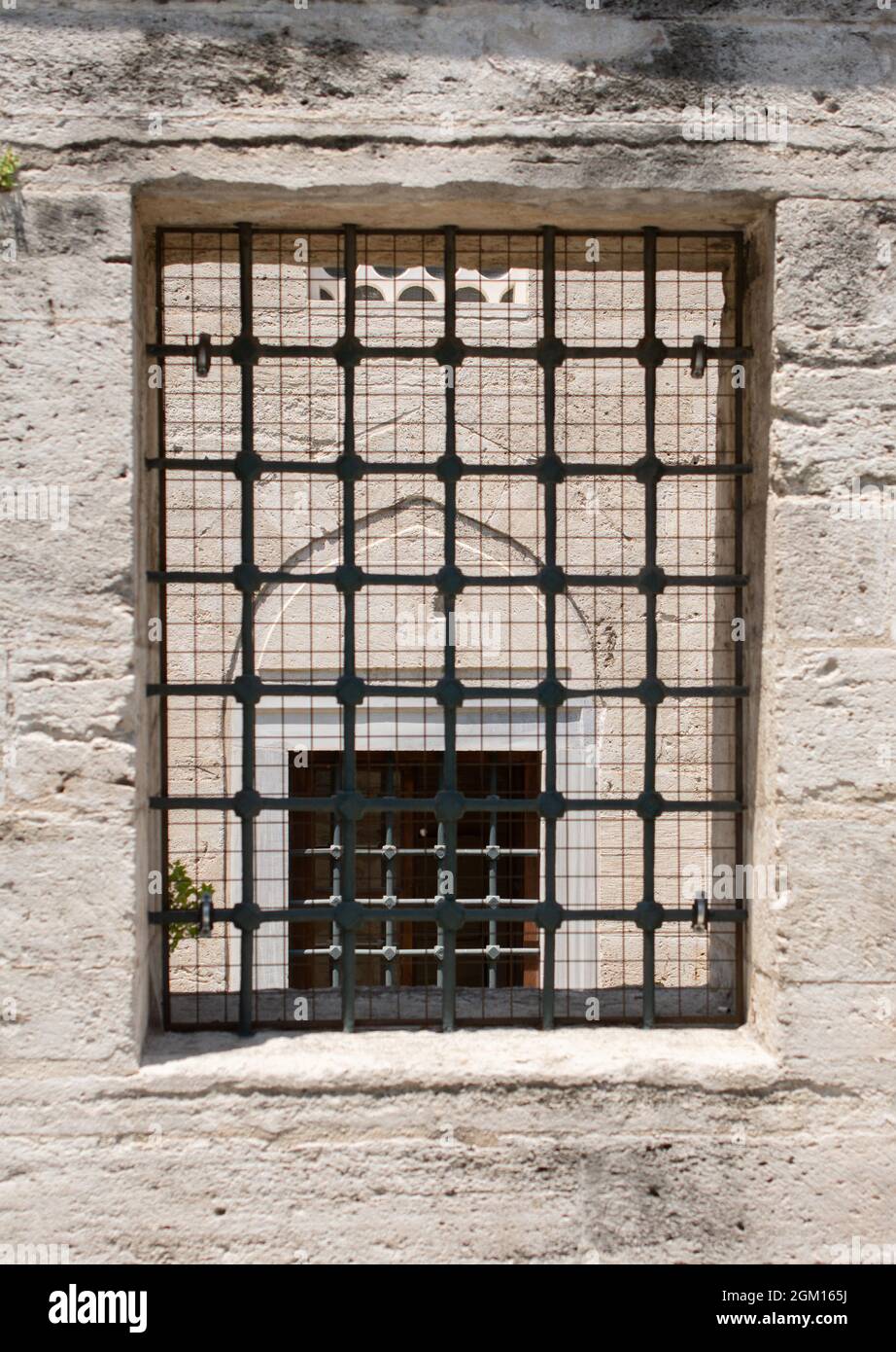 Vertical shot of a window with black bars on an old building under the ...