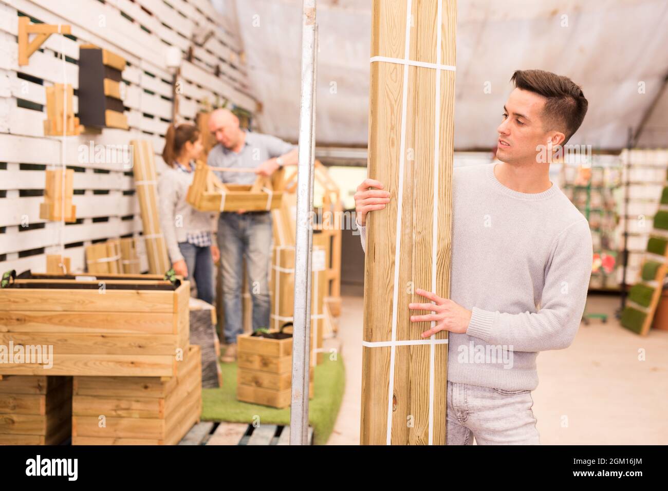 Portrait of positive man with purchases in hardware store Stock Photo ...