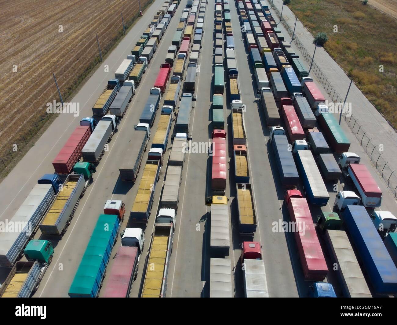 Trucks in line in the parking lot to the terminal in the port. Aerial ...