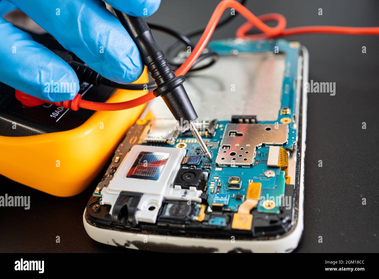 Technician repairing inside of mobile phone by soldering iron ...