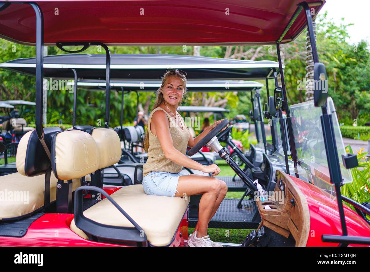 Blonde woman sitting and smiling in an electric tourist cart Stock ...