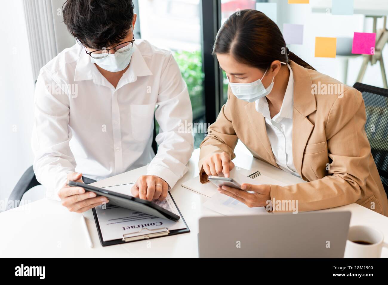 two coworkers helping each other to revise the contract before signing ...