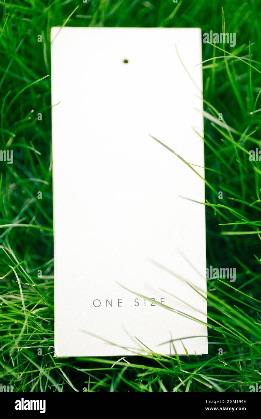 Top view of one white cardboard tag with the inscription one size ...