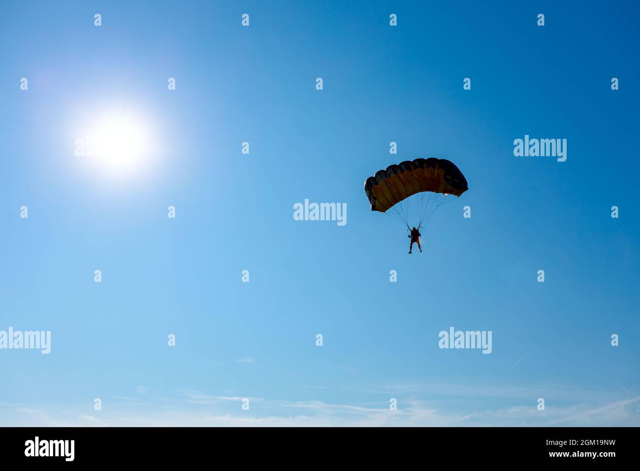 Parachutist is flying slowly down with an open parachute. Skydiving ...