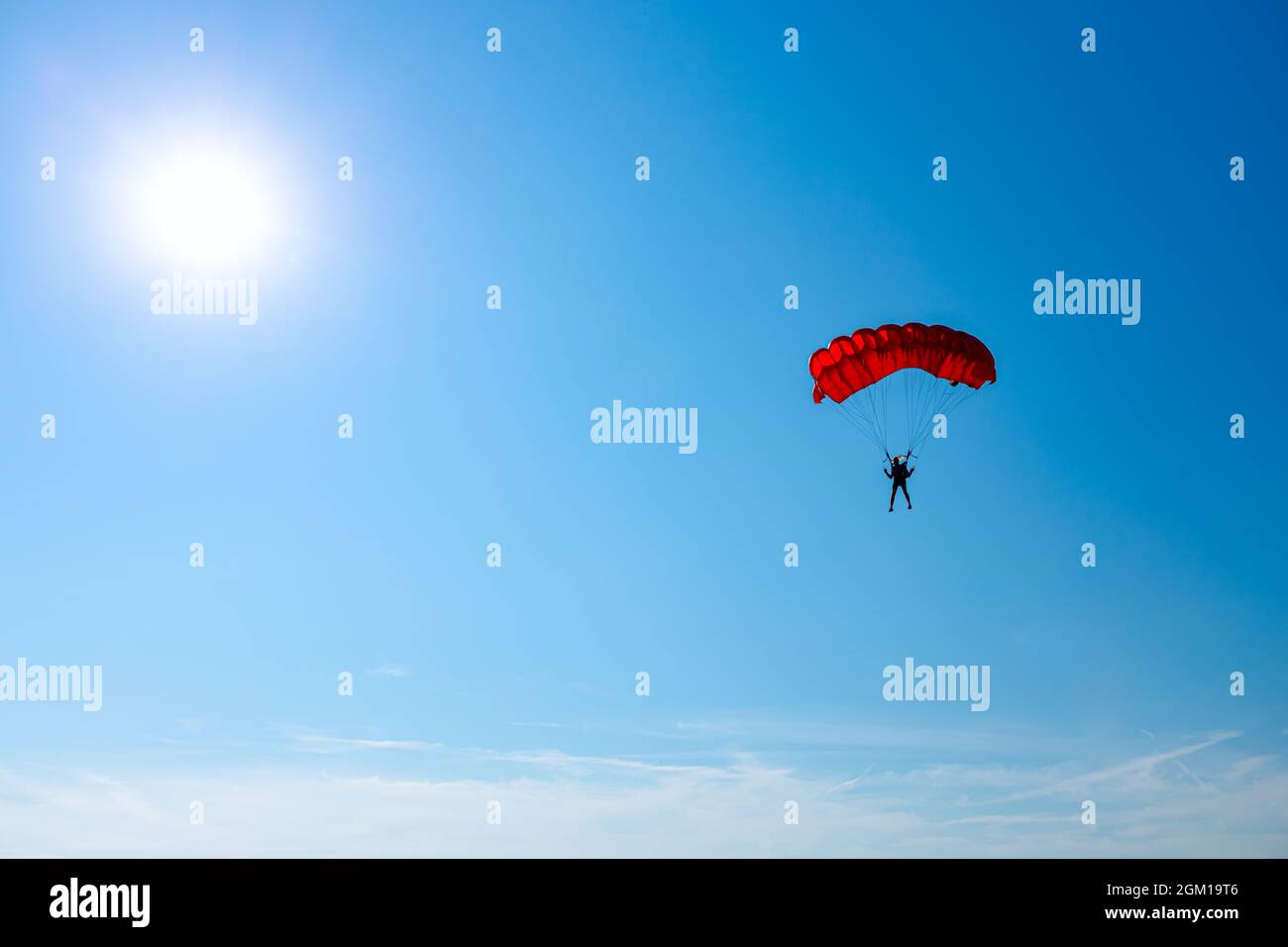 Parachutist is flying slowly down with an open parachute. Skydiving ...