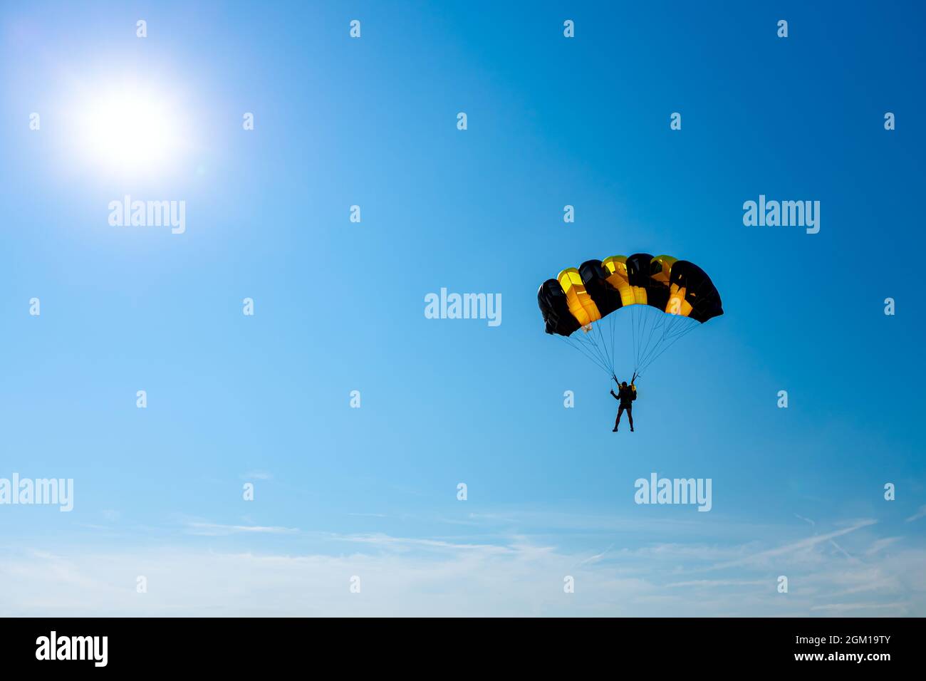 Parachutist is flying slowly down with an open parachute. Skydiving ...