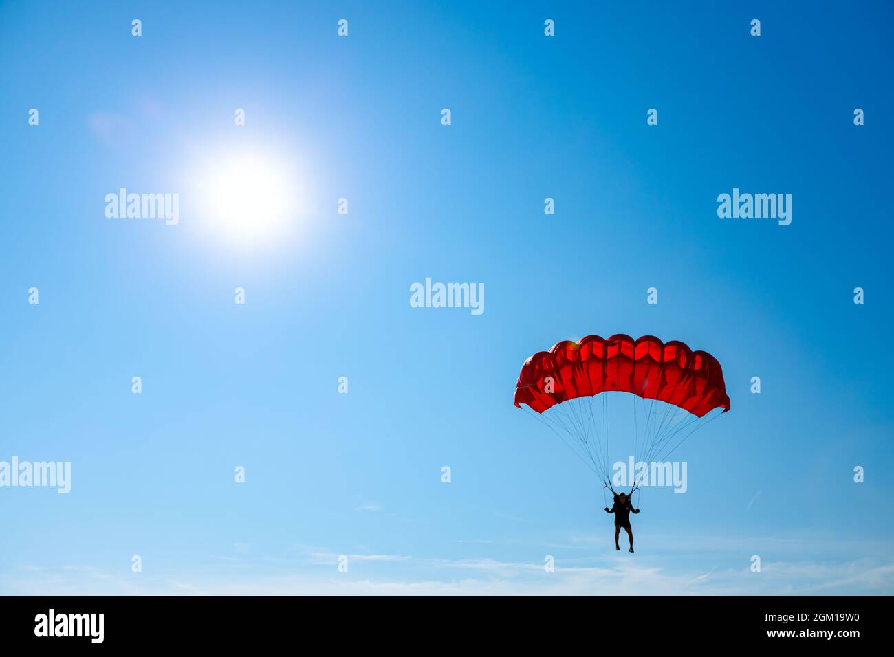 Parachutist is flying slowly down with an open parachute. Skydiving ...