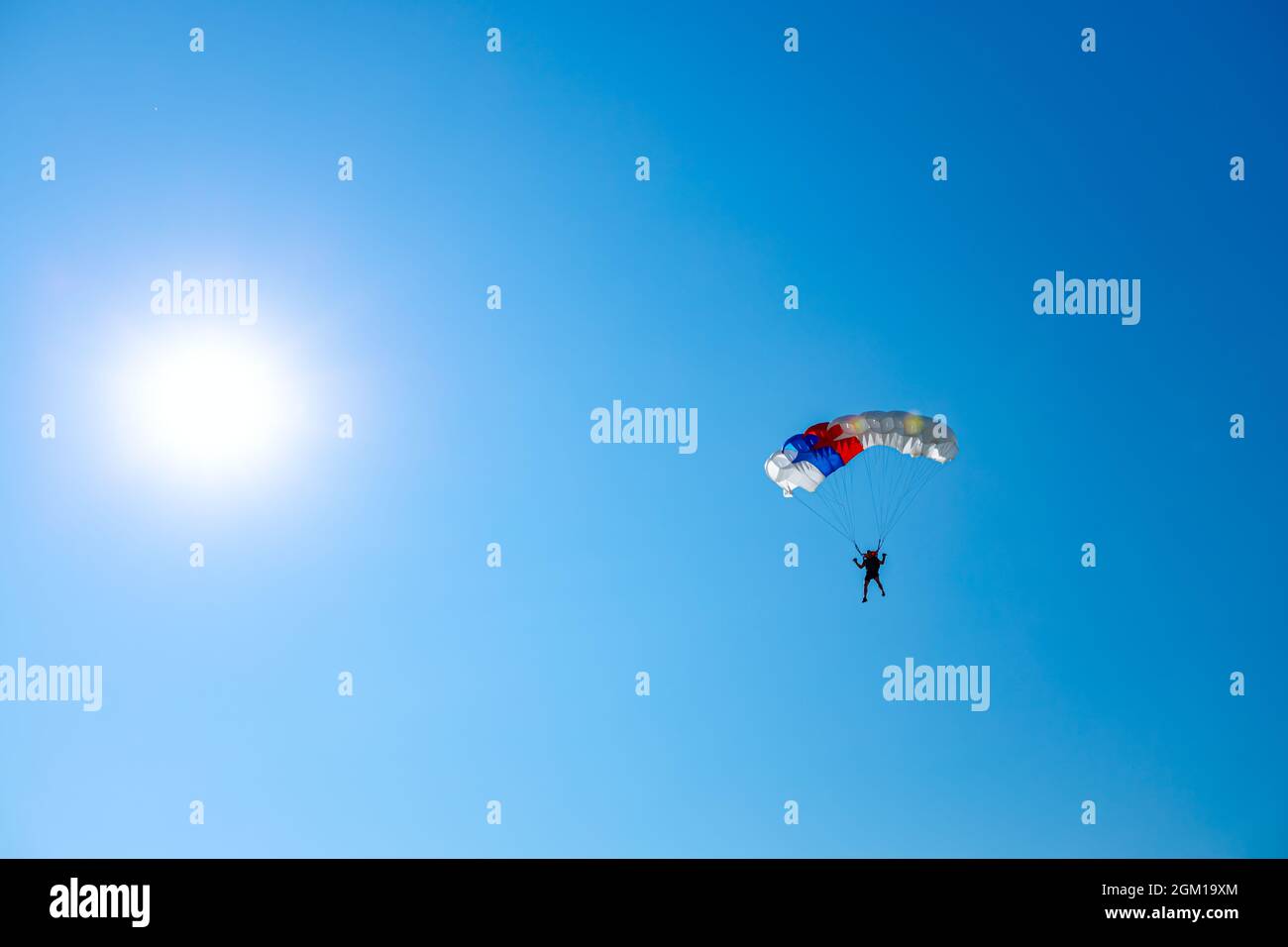 Parachutist is flying slowly down with an open parachute. Skydiving ...