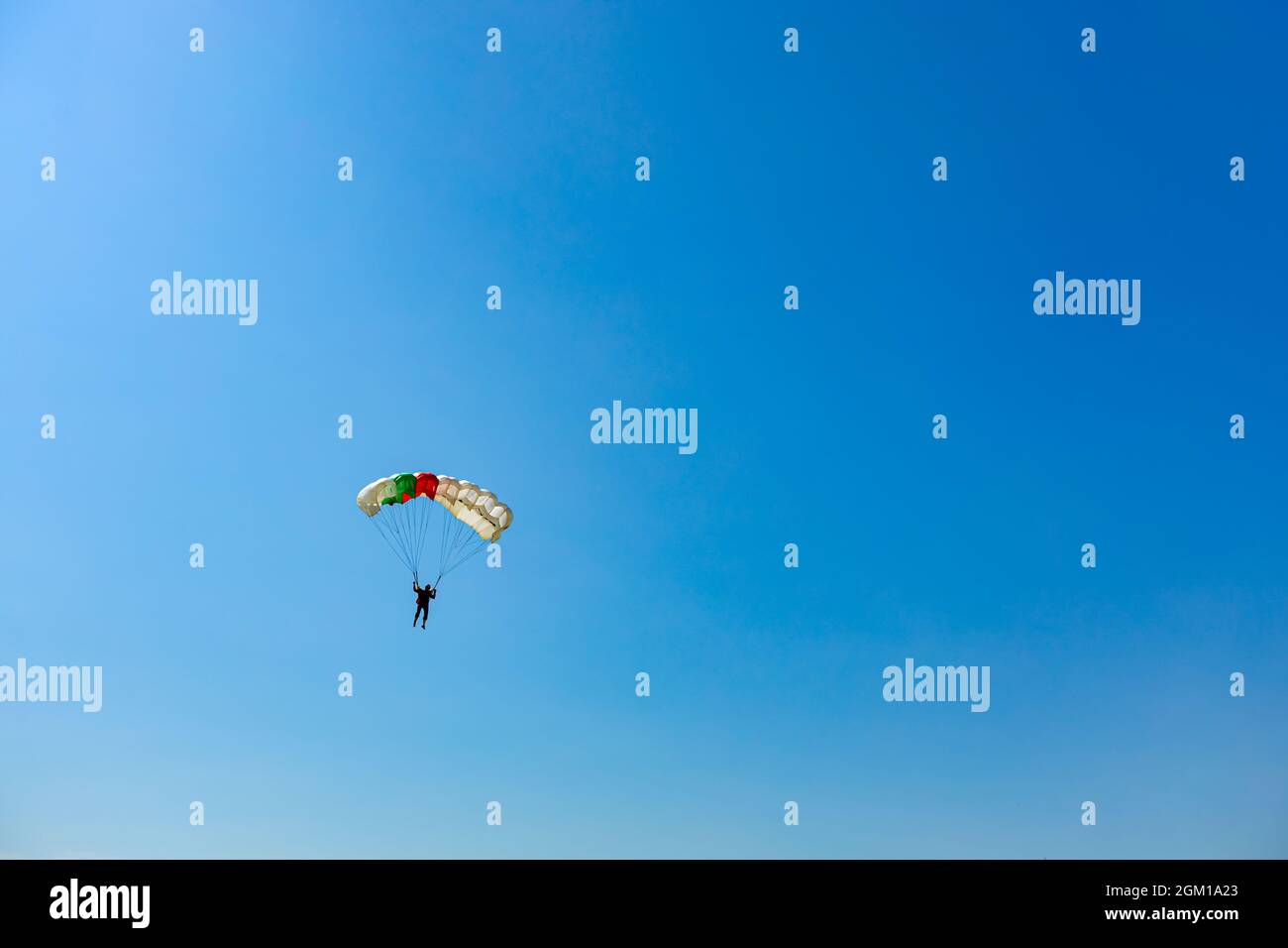 Parachutist is flying slowly down with an open parachute. Skydiving ...