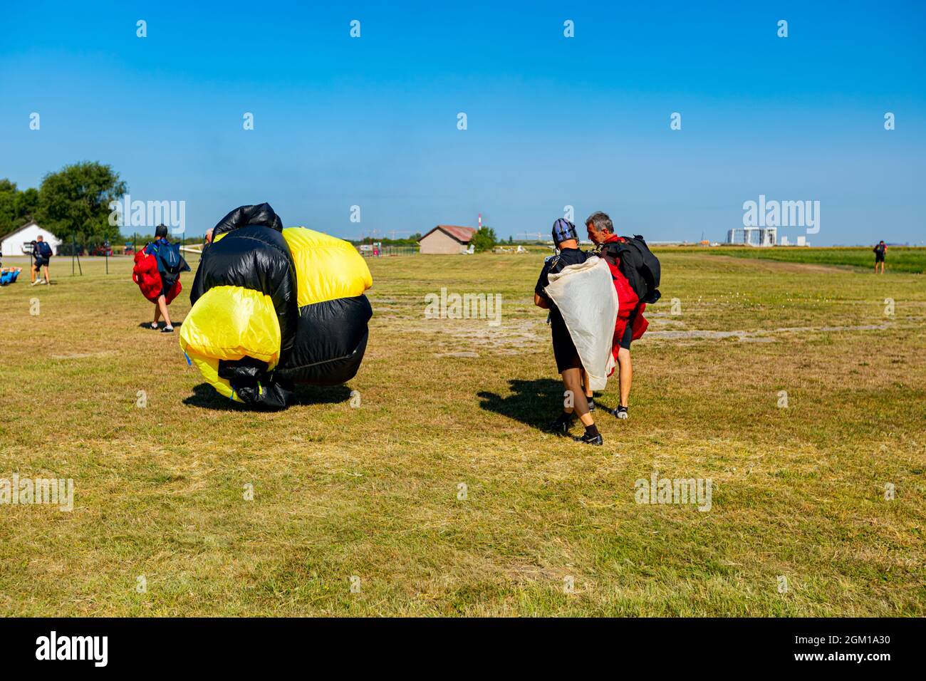 Paratroopers carry opened parachute walk over airfield at National ...