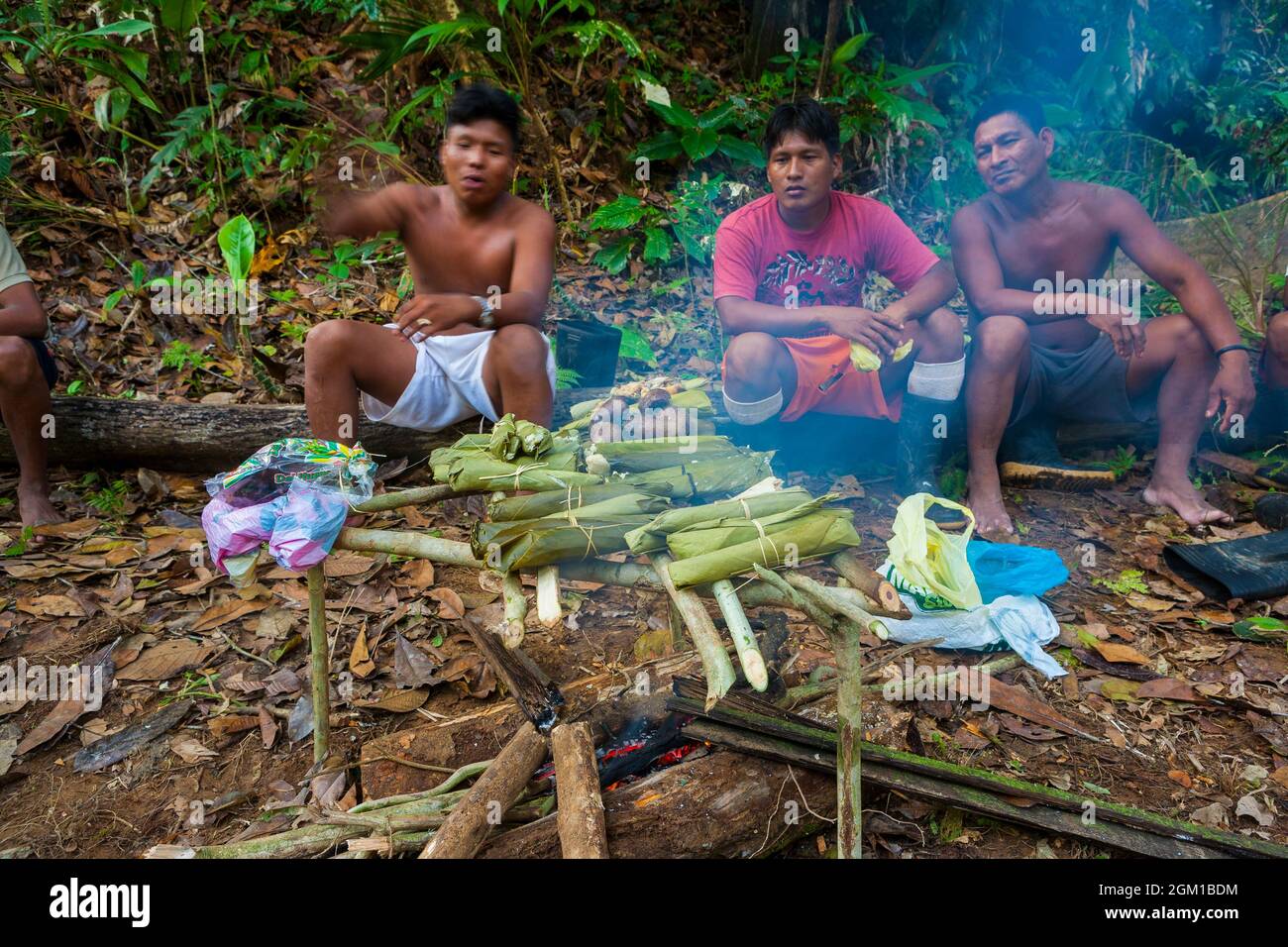 Embera indian men making food over a bonfire in the rainforest of ...