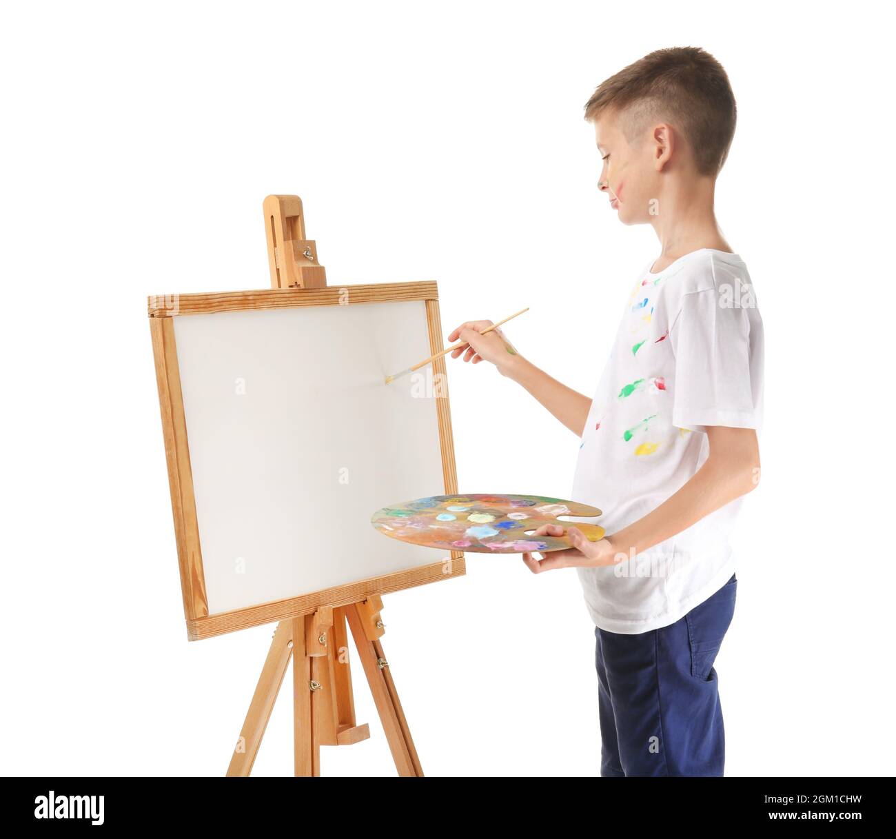 Cute little boy painting picture on canvas against white background ...