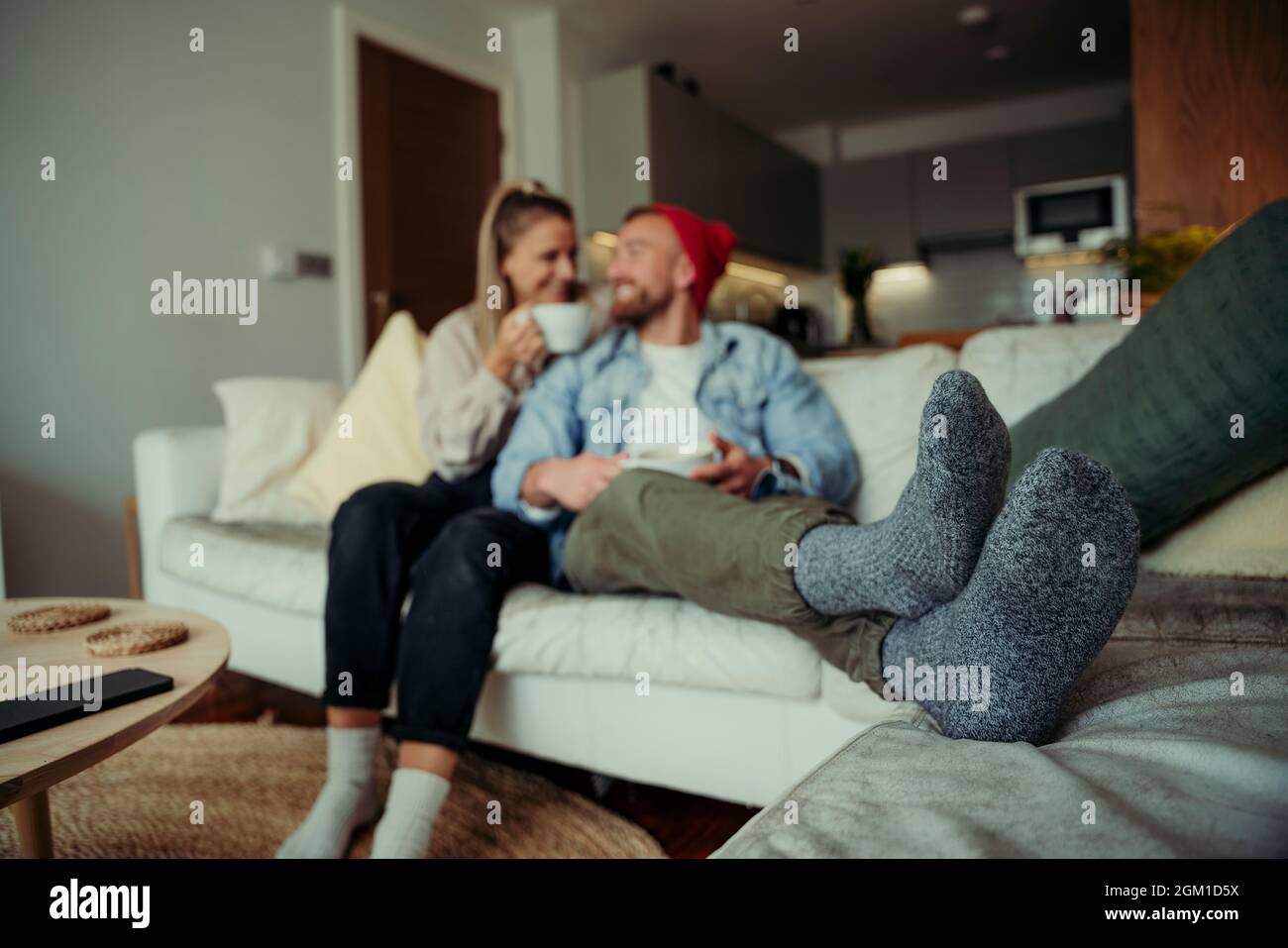 Couple cuddling on sofa hi-res stock photography and images - Alamy