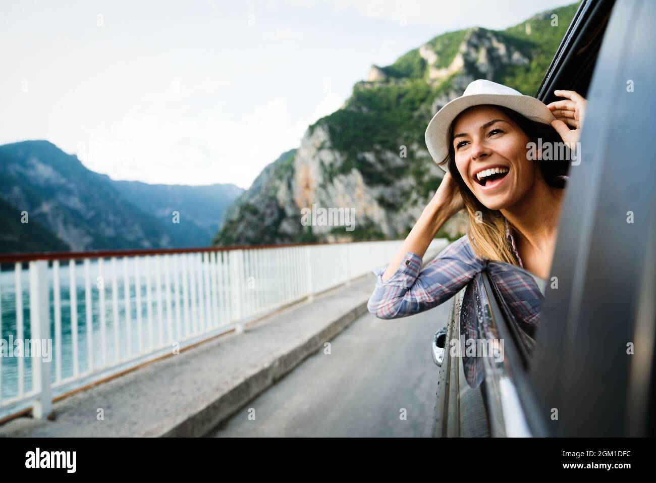 Woman in car road trip waving out the window smiling Stock Photo - Alamy