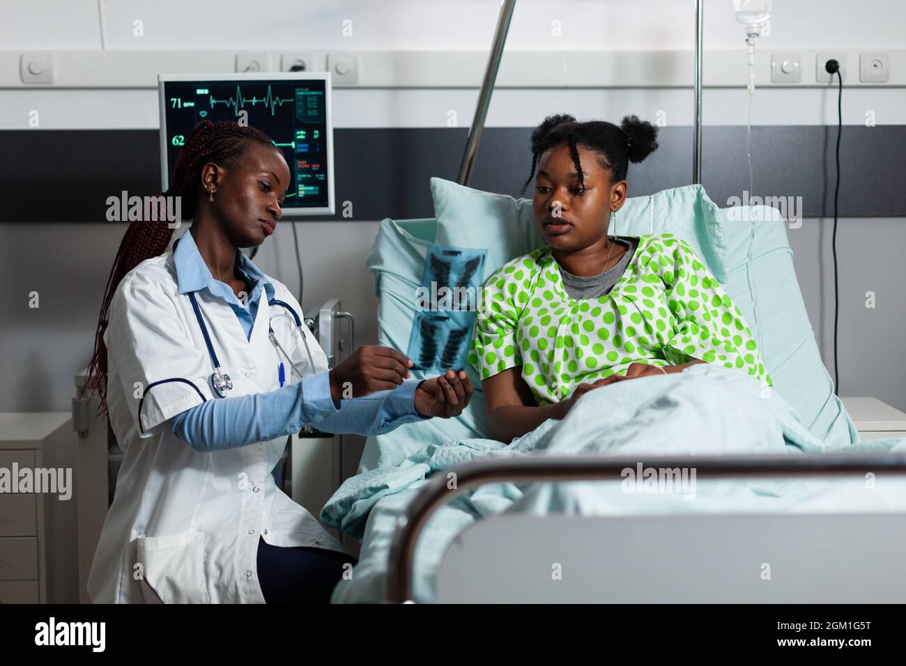 Woman with doctor occupation holding x ray results with patient in ...
