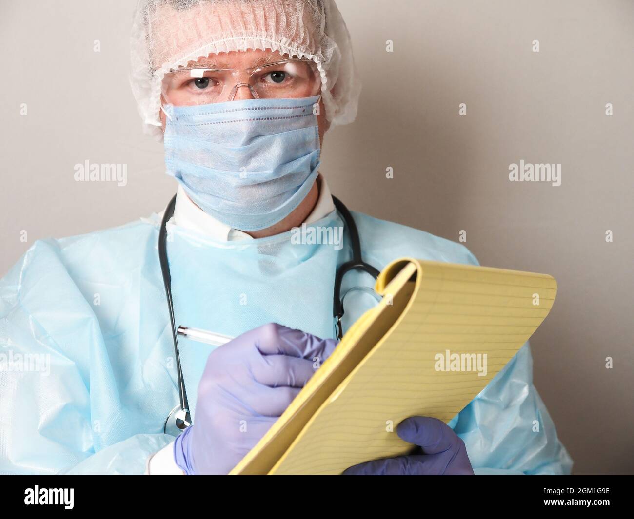 Doctor wearing mask, glases and gloves with a notepad Stock Photo - Alamy