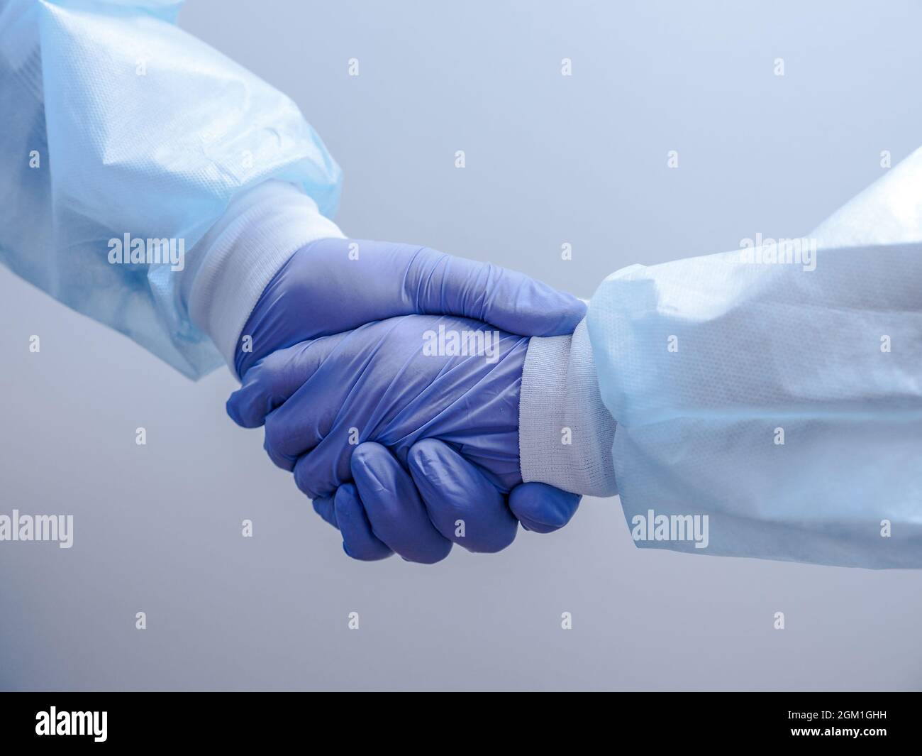 Handshake of two doctors' hands in medical gloves Stock Photo - Alamy