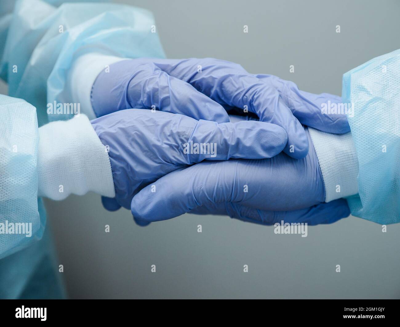Blue glove handshake hi-res stock photography and images - Alamy