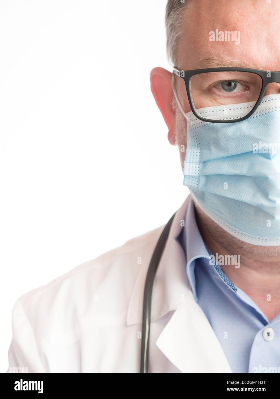 Portrait of a medical doctor wearing a facemask, on white background ...
