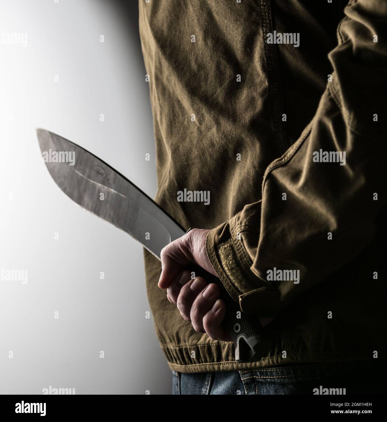Man hiding a machete behind his back Stock Photo - Alamy
