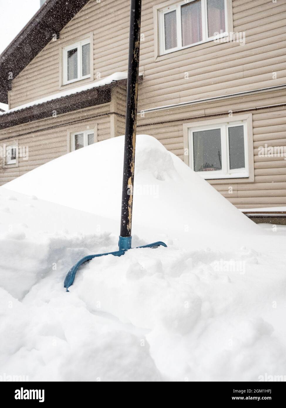 A shovel in a large heap of snow in front of the house Stock Photo - Alamy