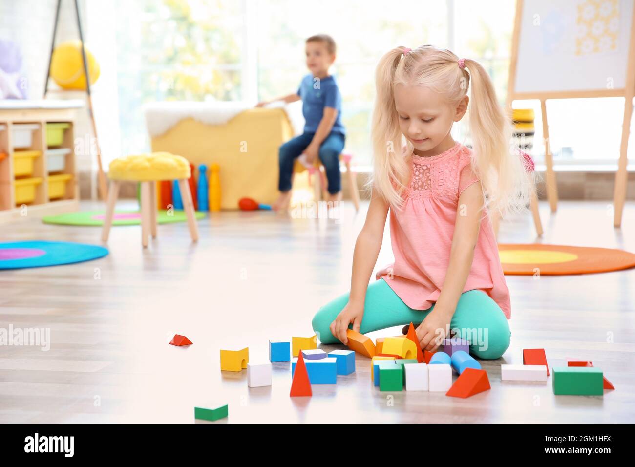 Cute little girl playing with blocks at home Stock Photo - Alamy