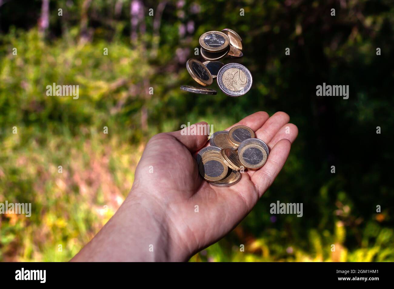 Euro coins falling into hand. Raining money Stock Photo - Alamy