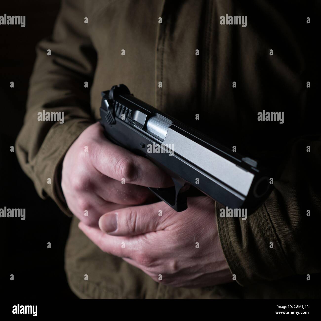 Man holding a gun ready to shoot Stock Photo - Alamy