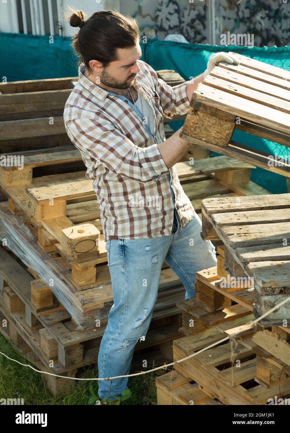 Man laying wooden pallets Stock Photo - Alamy