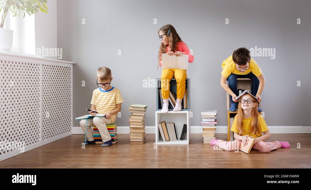 Group of children sitting in the room and reading books Stock Photo - Alamy