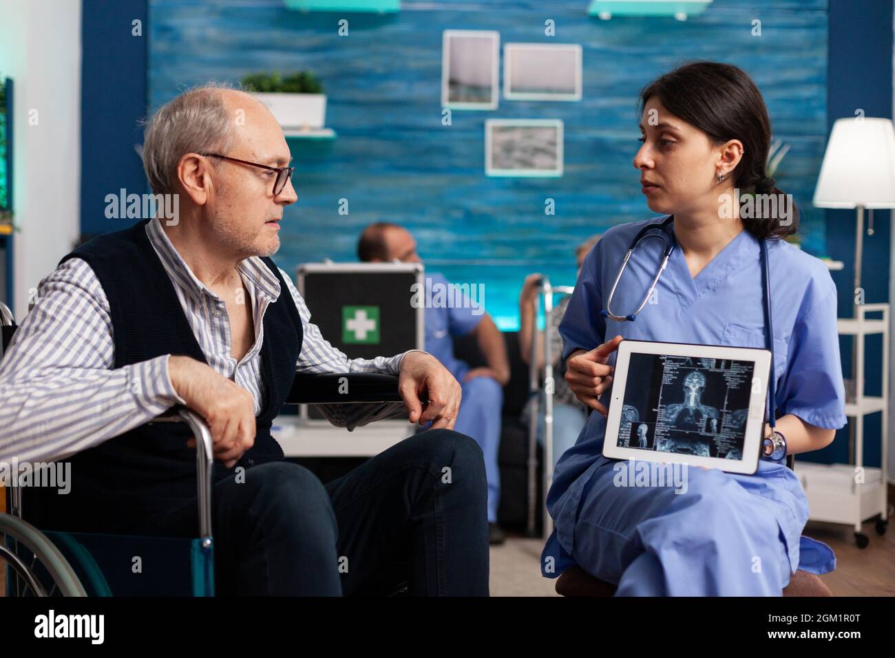 Social nurse worker explaining medical radiography using tablet ...