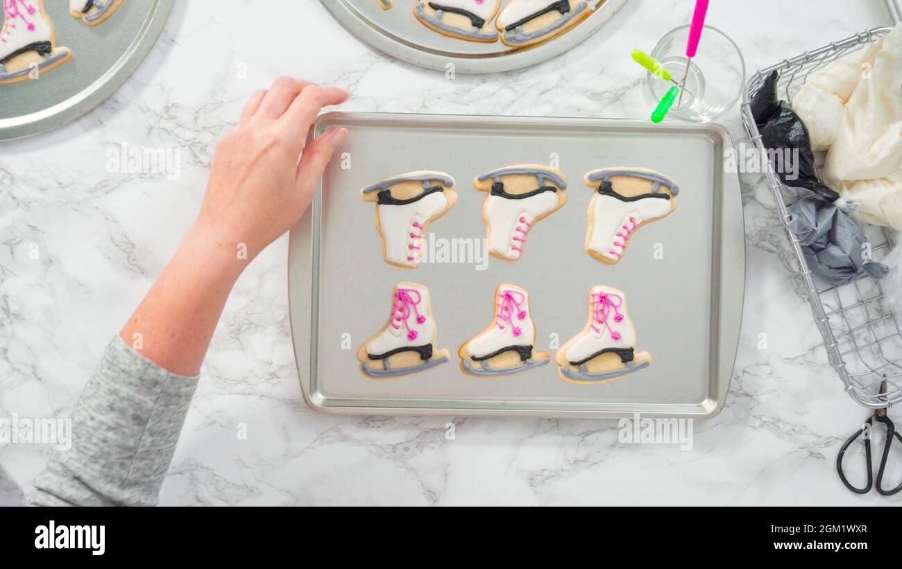 Flat lay. Icing figure skate shaped sugar cookies with royal icing ...