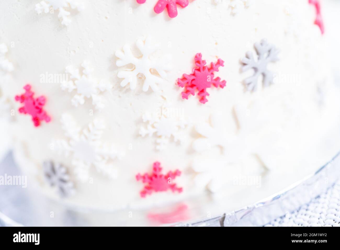 Frosting a tall round cake with white Italian buttercream icing and ...