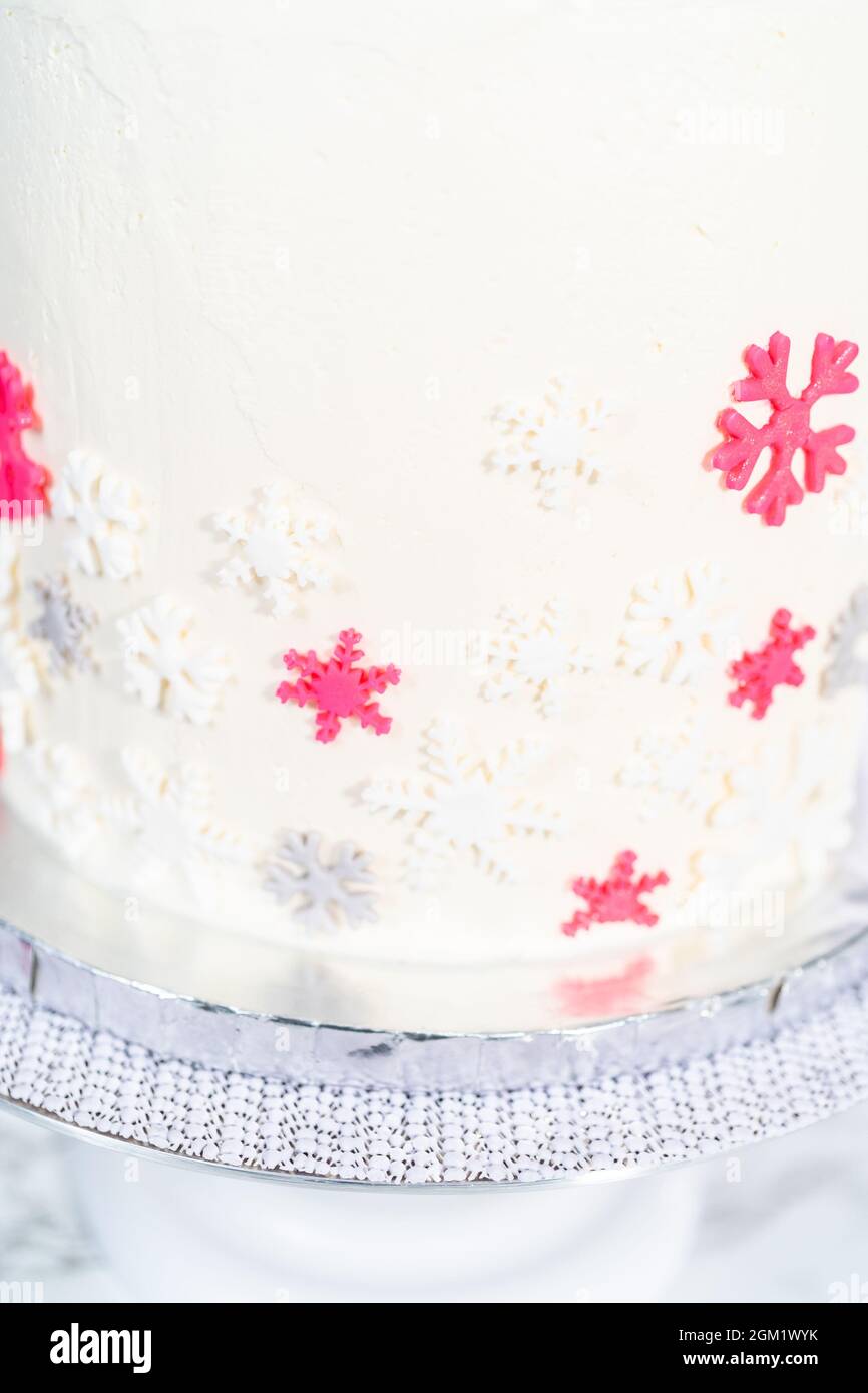 Frosting a tall round cake with white Italian buttercream icing and ...