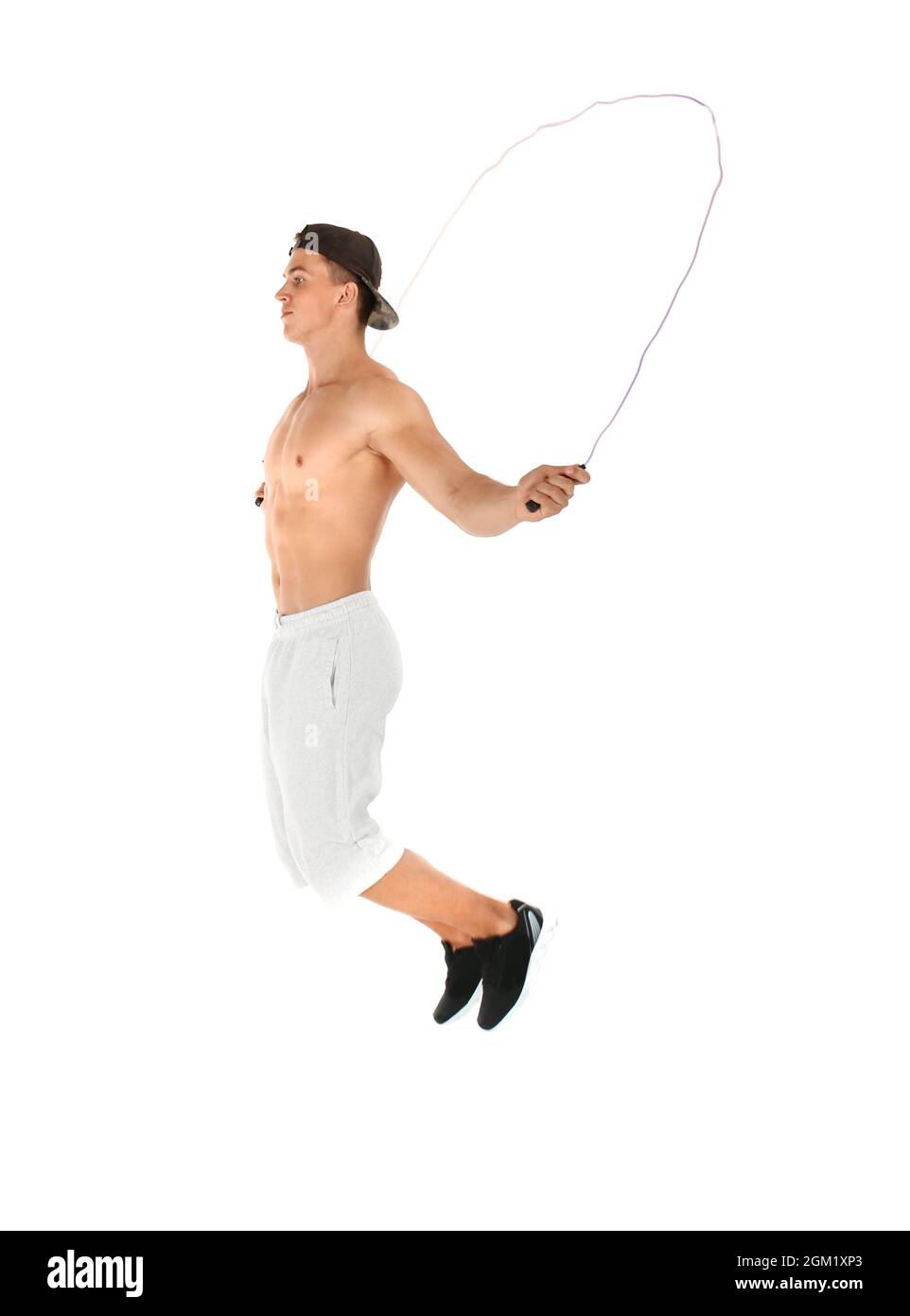 Sporty young man jumping rope on white background Stock Photo - Alamy