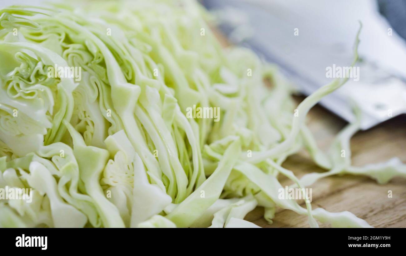 Step by step. Shredded organic cabbage on a wood cutting board Stock ...