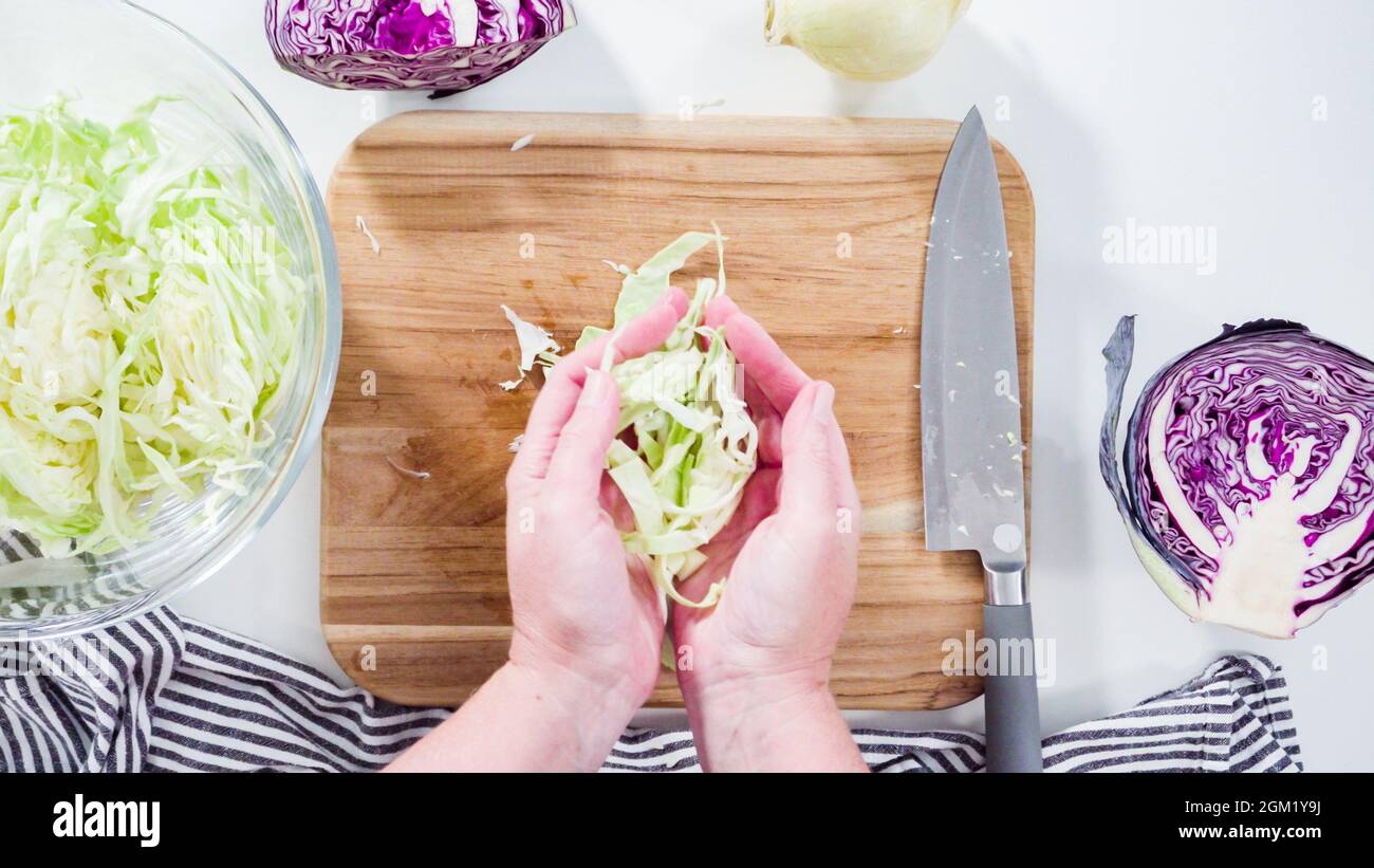 Flat lay. Step by step. Shredding organic cabbage on a wood cutting ...